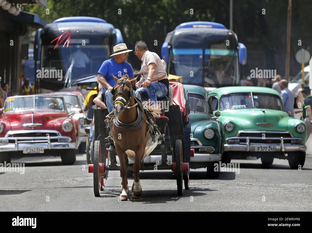Tourist buses share the road along with vintage American cars and a ...