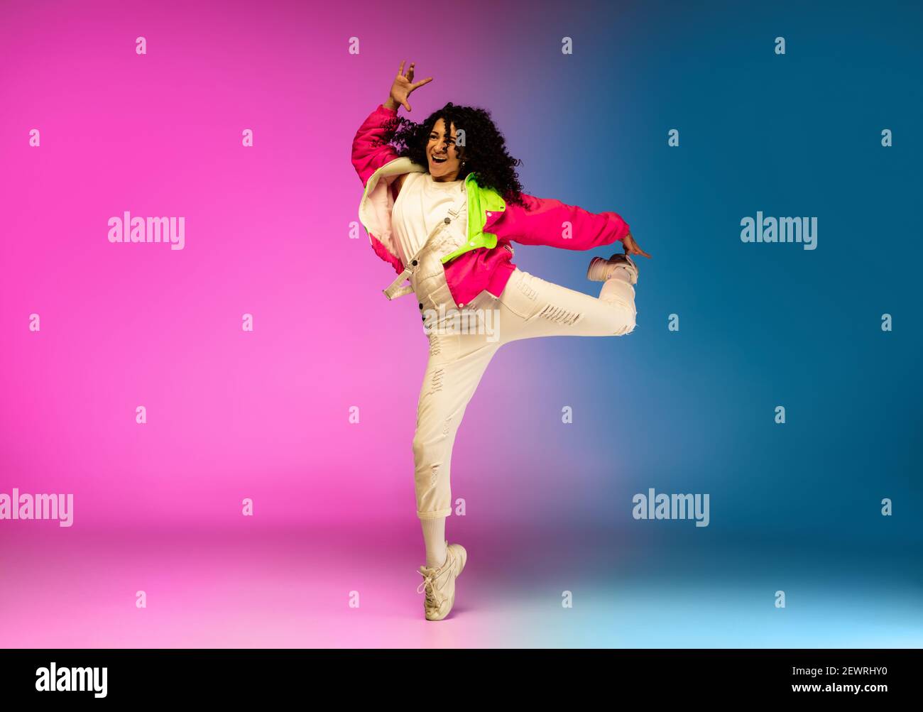 Stylish sportive caucasian woman dancing hip-hop on colorful gradient ...