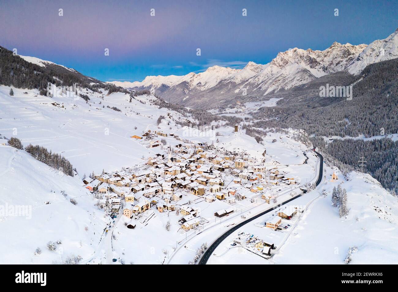 Mountain road crossing the village of Ardez covered with snow, aerial ...
