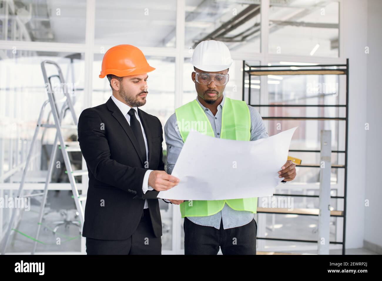 Multiracial men controlling process of construction Stock Photo - Alamy