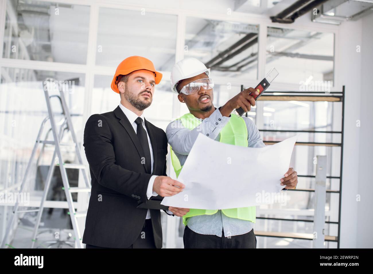 Multiracial men controlling process of construction Stock Photo - Alamy
