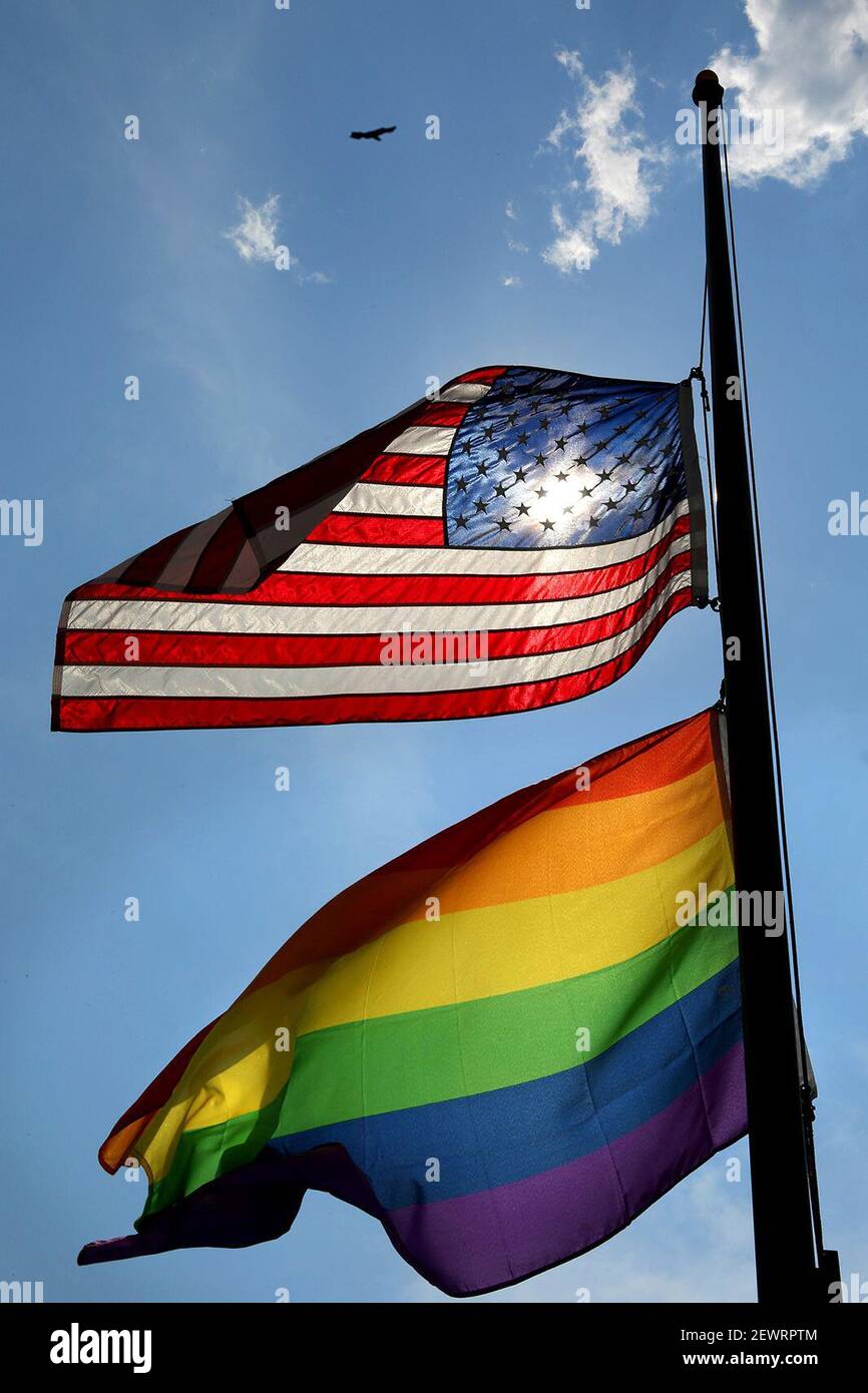 The U.S. and gay pride flags fly at half-mast over the GLBT Community ...