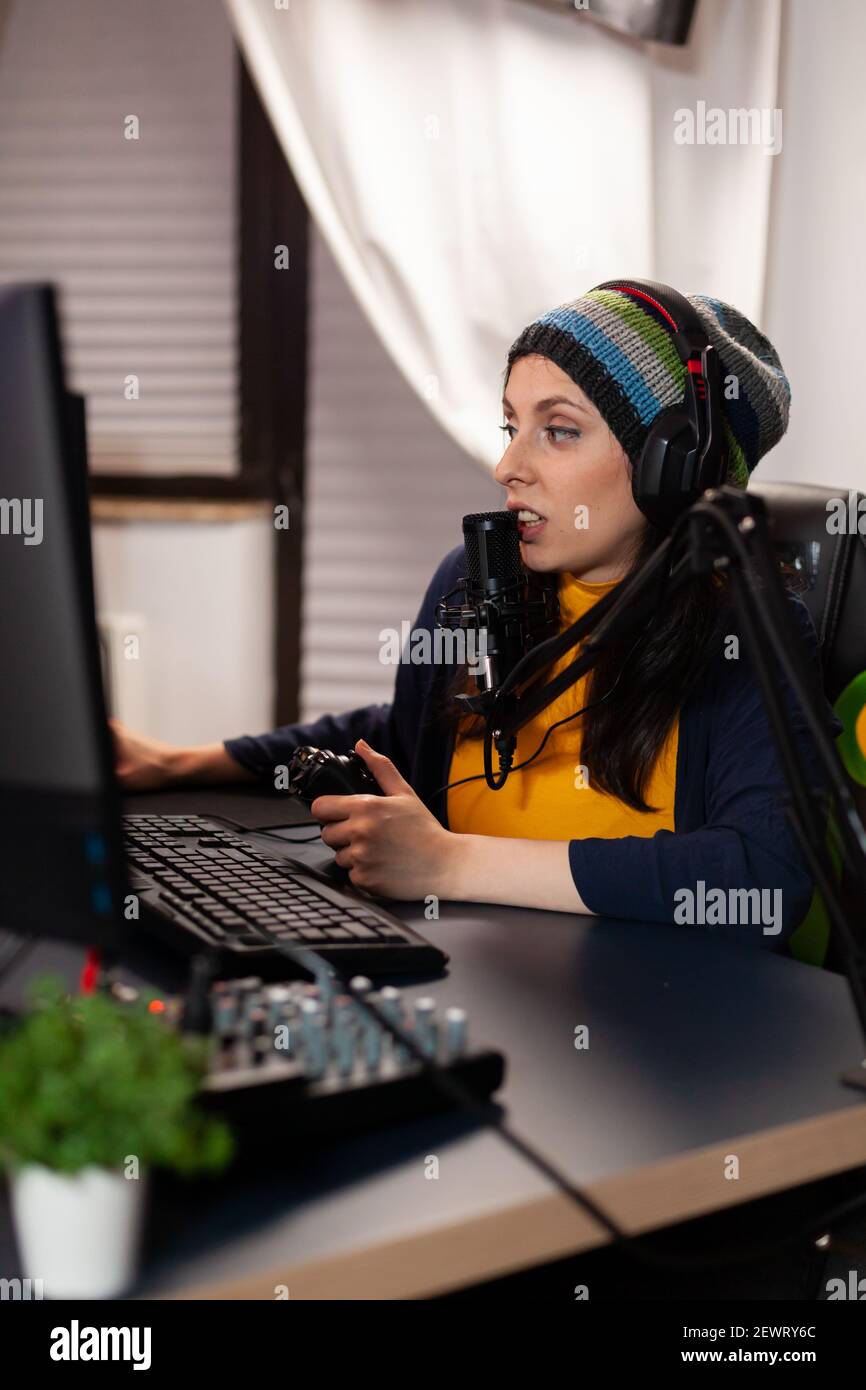 Side view of pro streamer with headphone playing shooter game ...