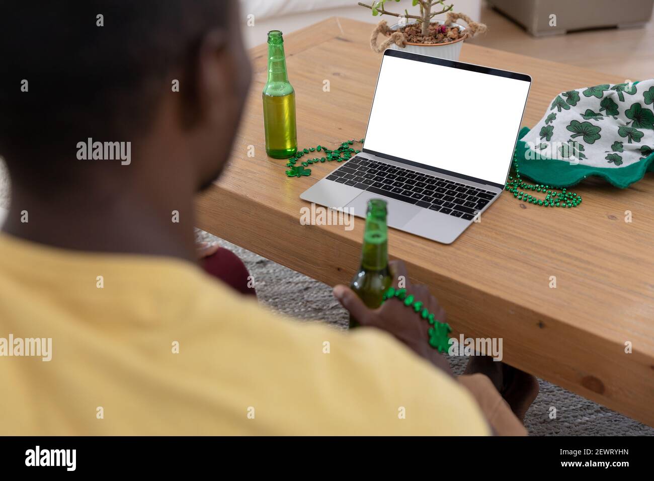 African american man holding bottle of beer making st patrick's day ...