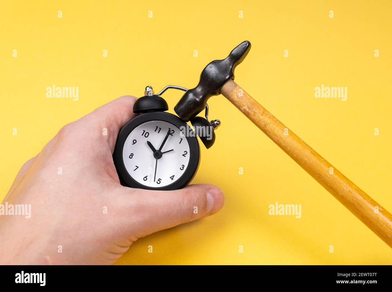 Smashing alarm clock with hammer concept for sleeping in, tired ...