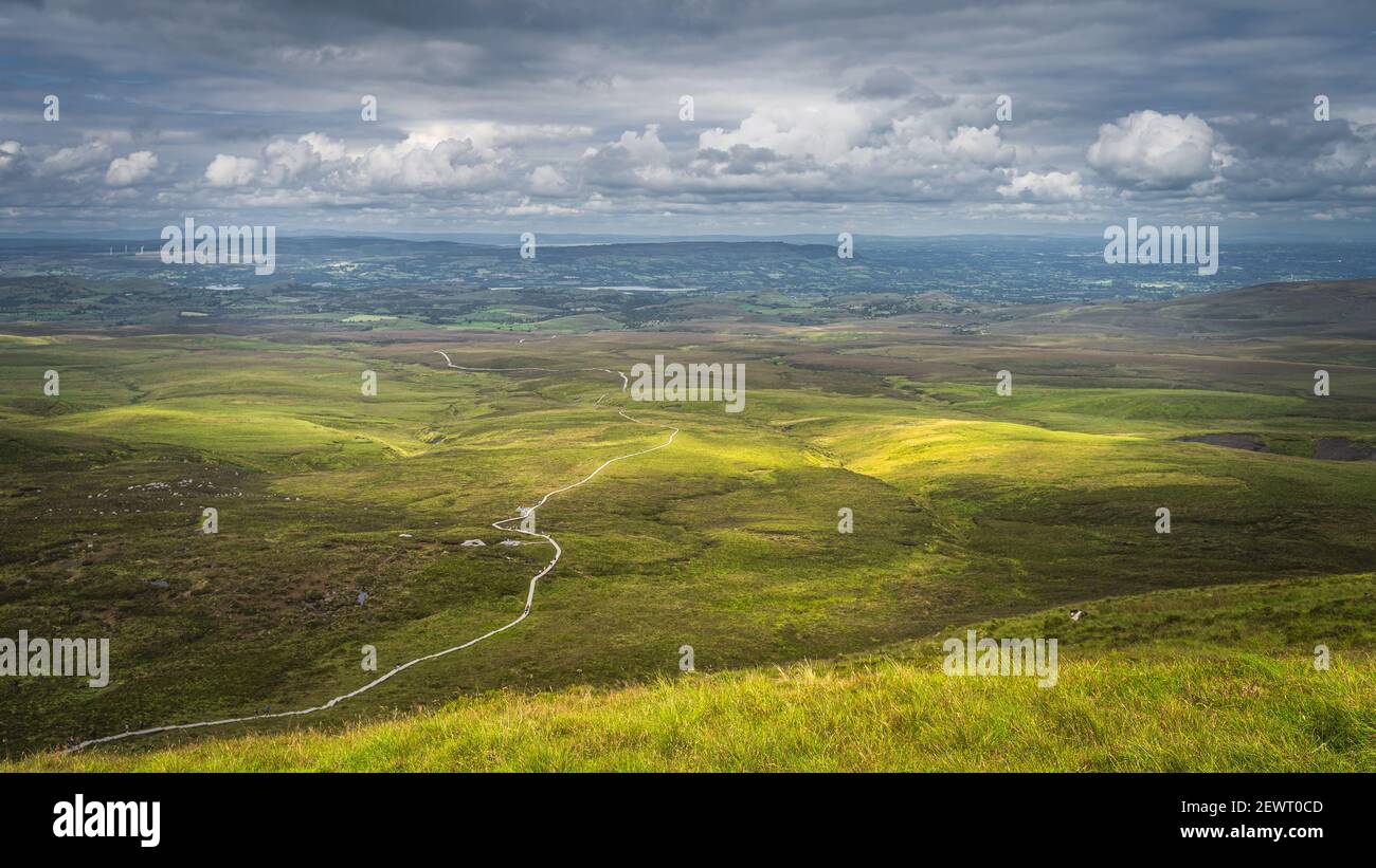 Winding wooden path of Cuilcagh Mountain Park boardwalk, illuminated by ...