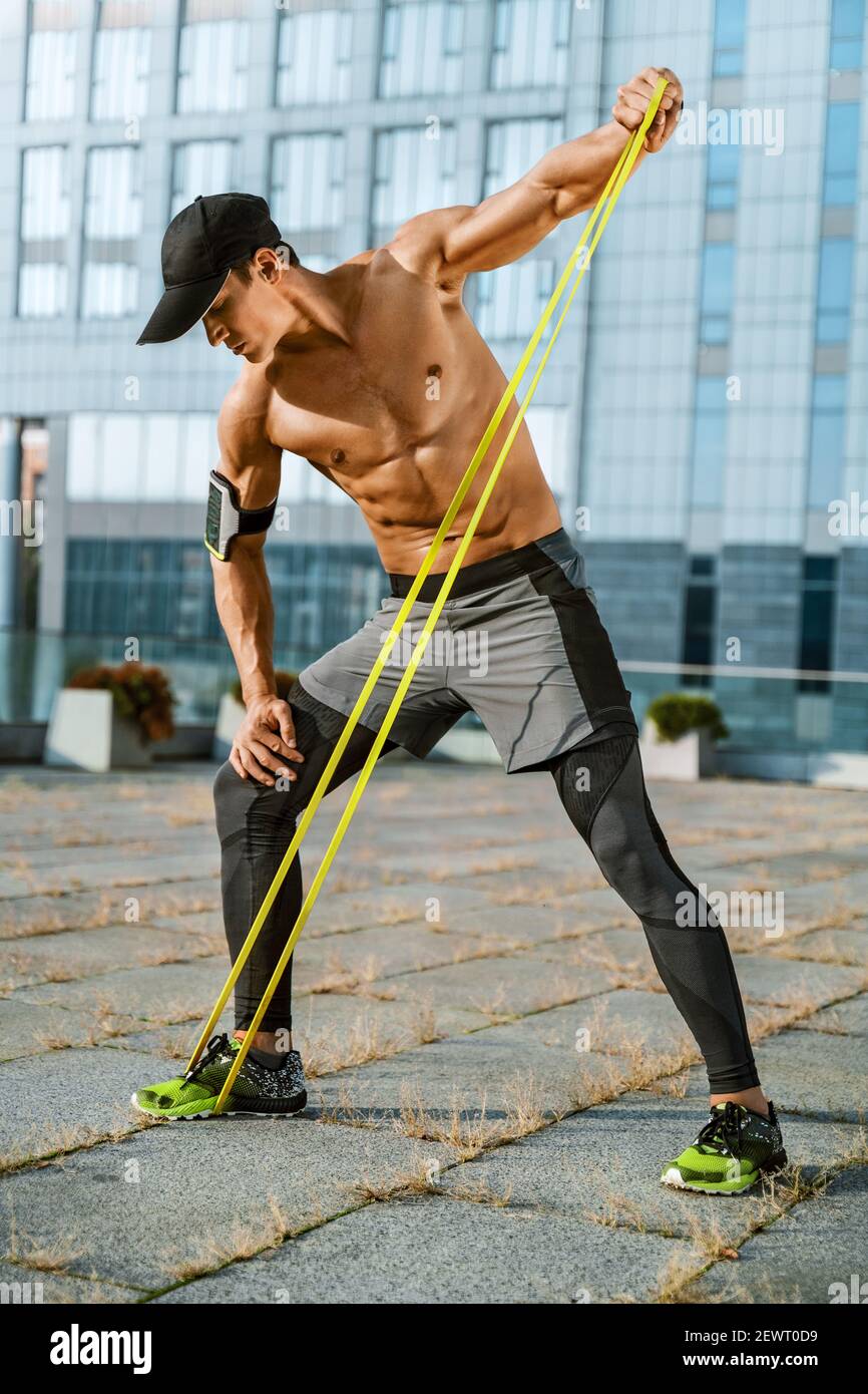 Strong man working with resistance band. Photo of man with athletic ...