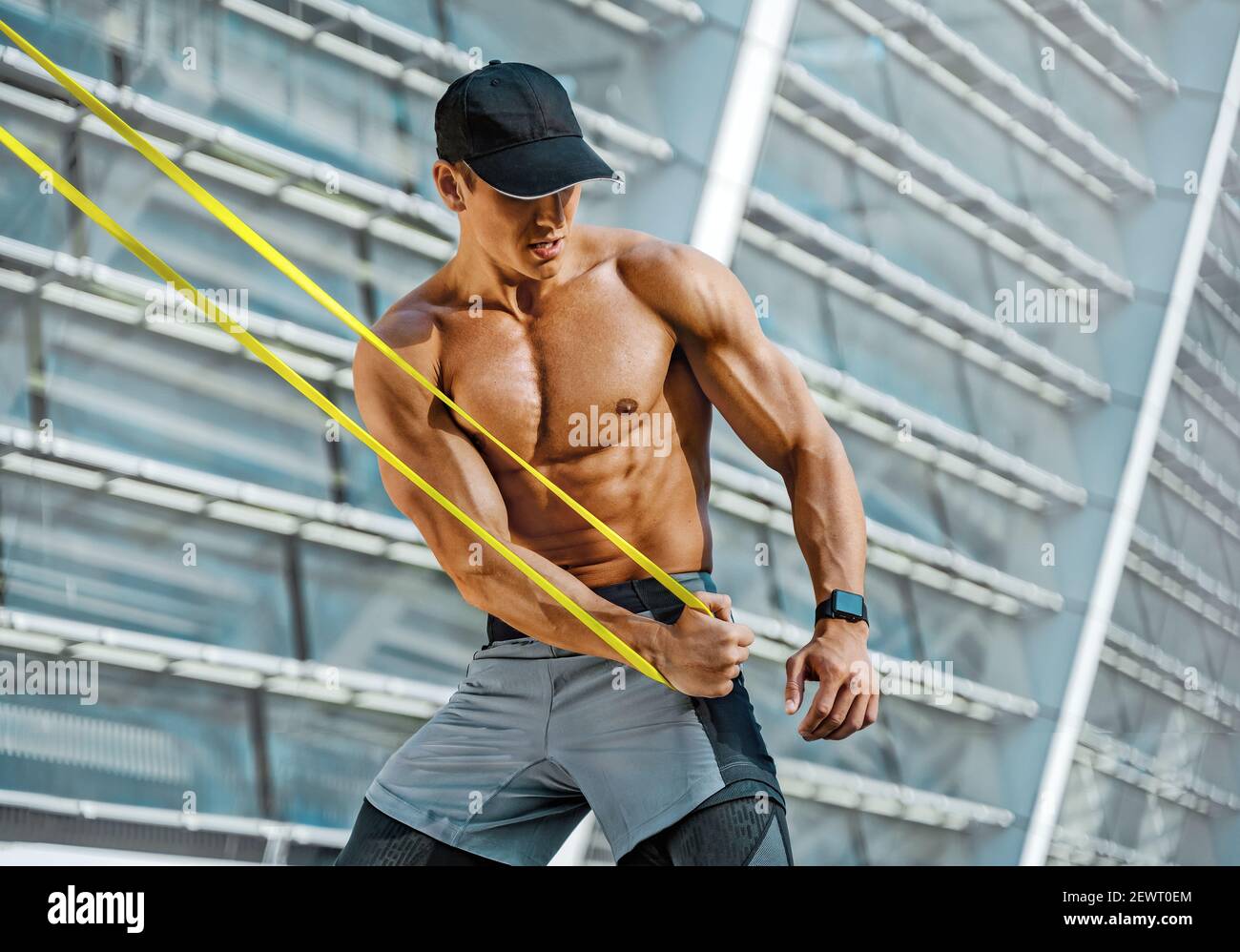 Athletic man performs exercises using resistance band. Photo of strong ...