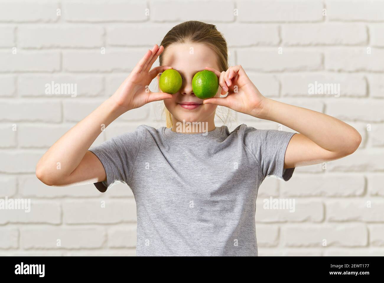 happy girl having fun and covering her eyes with lime , healthy eating ...