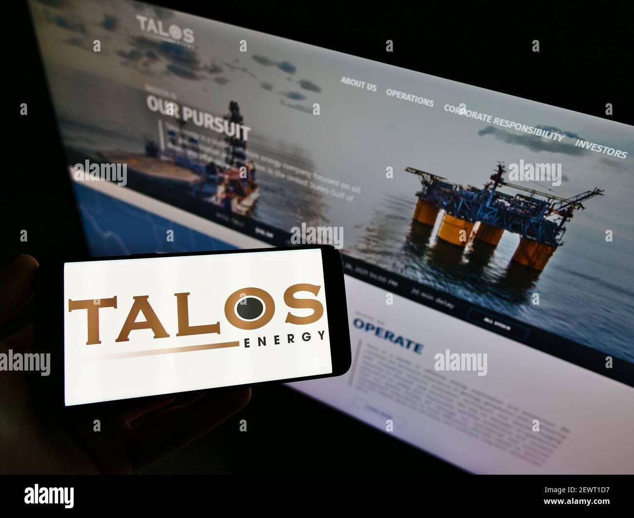 Person holding smartphone with logo of US oil and gas company Talos Energy Inc. on screen in ...