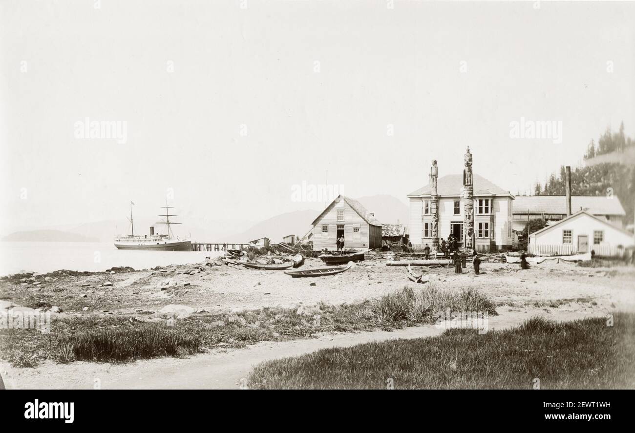 Vintage c.1900 photograph: Buildings and totem poles beside water ...