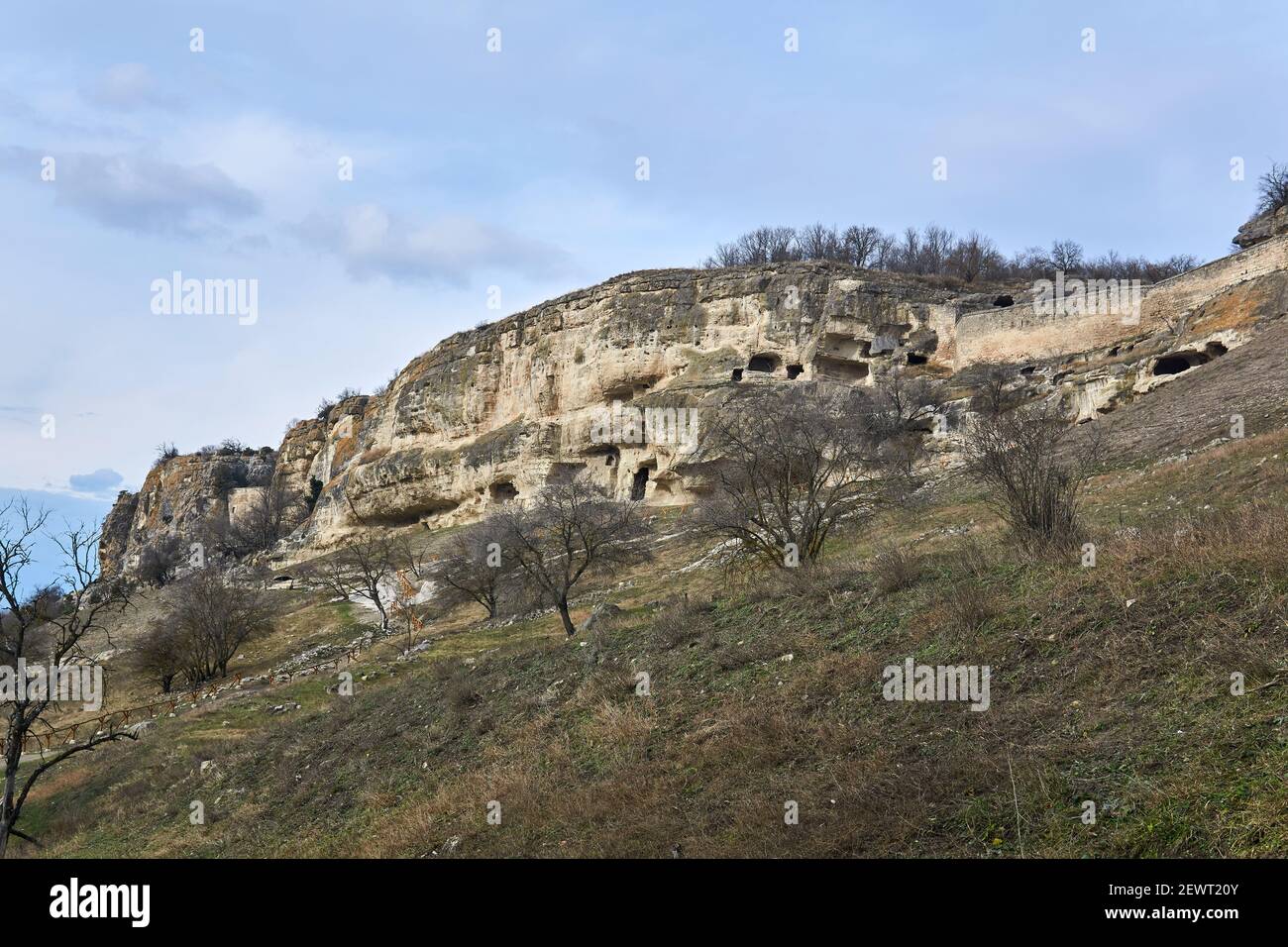 view of the ruins of a medieval cave city-fortress on a rocky slope ...
