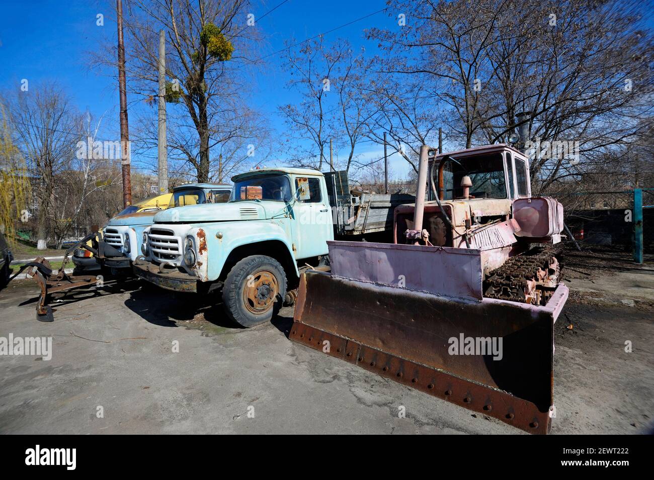 An old bulldozer and trucks parked at the backyard of the trolley depot ...