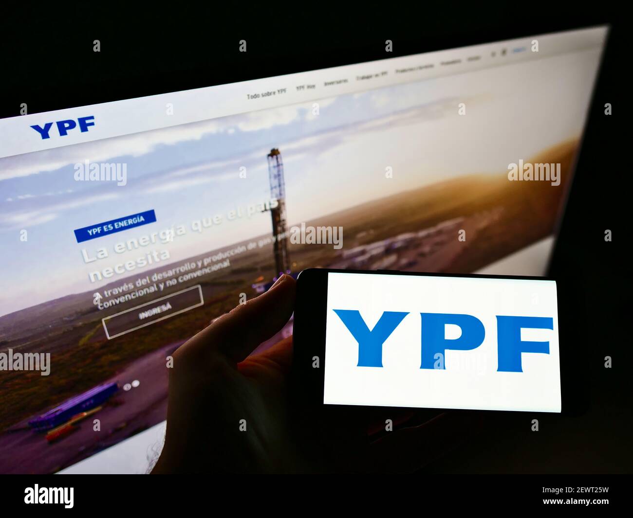 Person holding smartphone with logo of Argentinian energy company YPF S ...