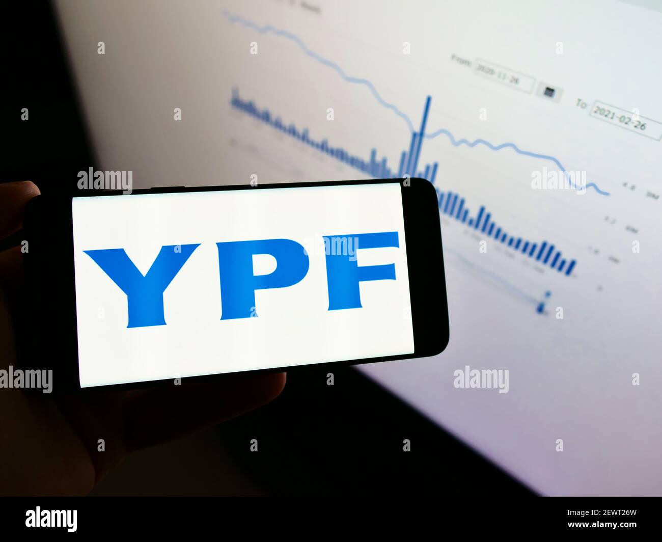 Person holding mobile phone with logo of Argentine oil and gas company ...