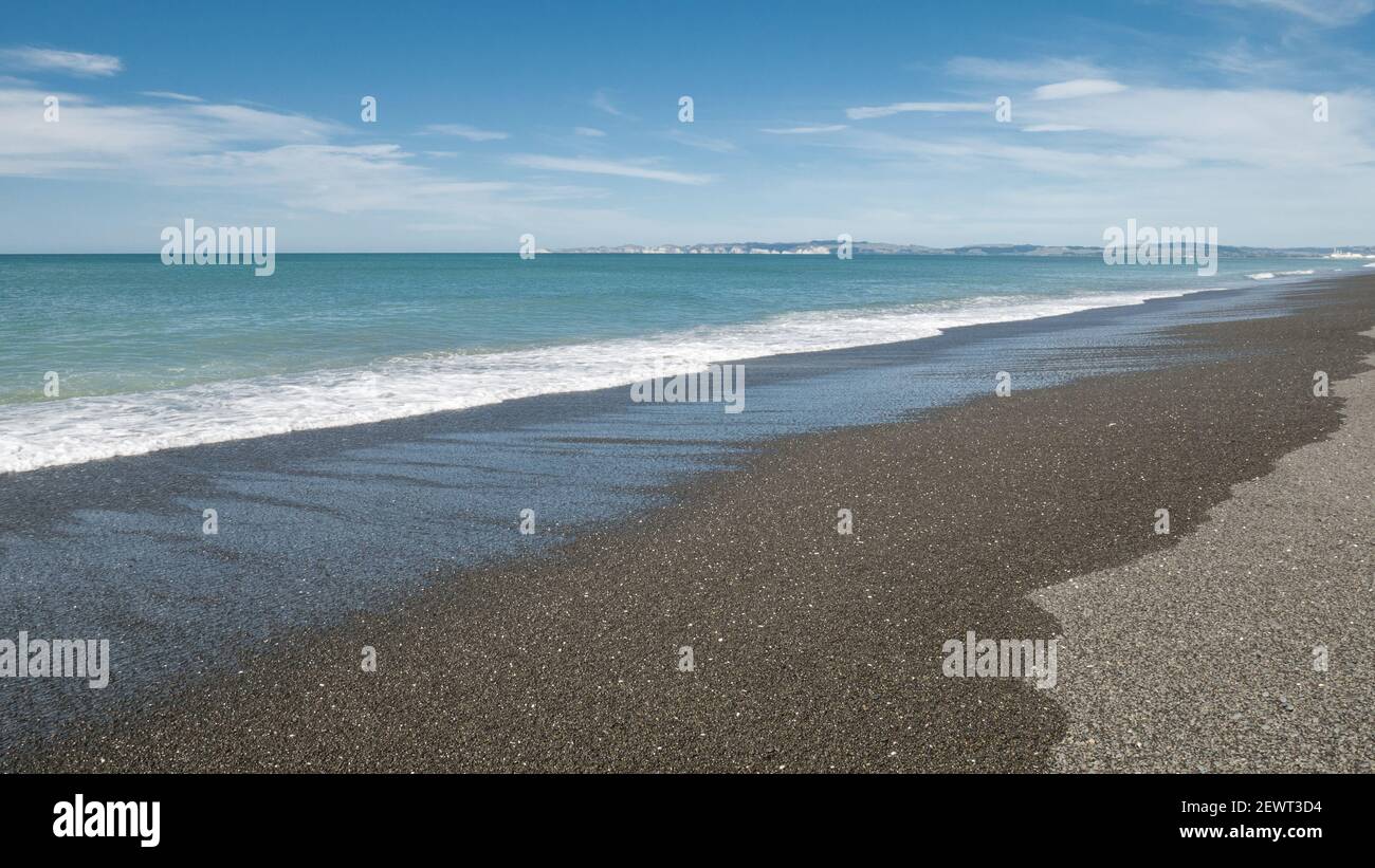 Coastal scenery with calm ocean and beach with blue sky backdrop. Shot ...