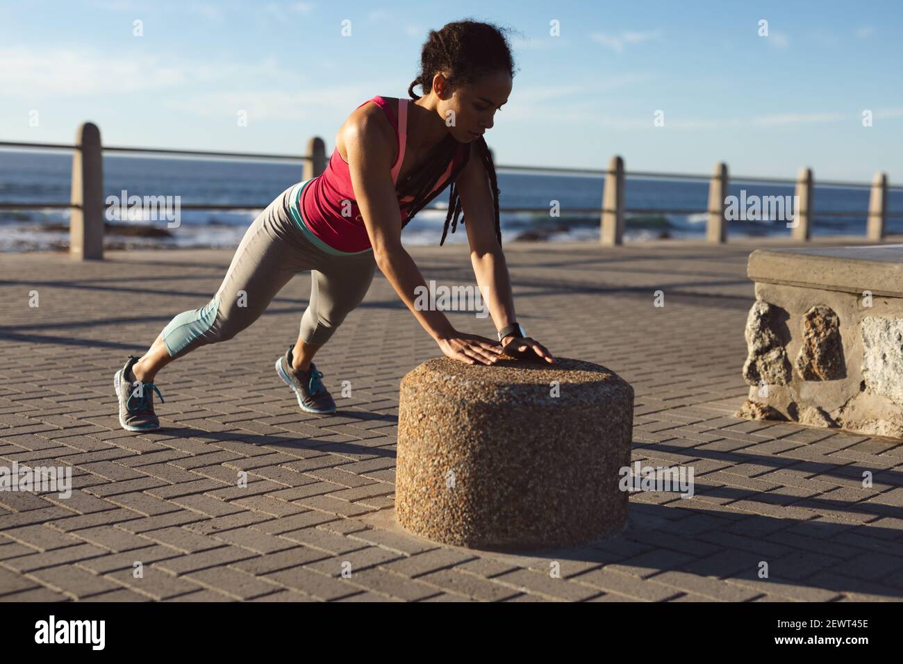African american woman concentrating exercising on a promenade by the ...
