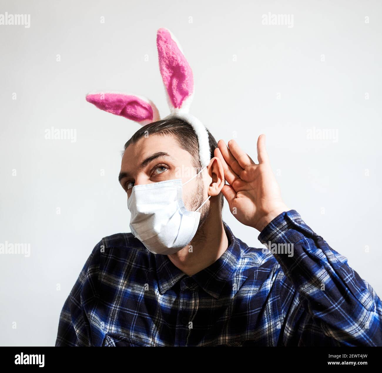 Charming young Caucasian man wearing medical protective mask and pink ...