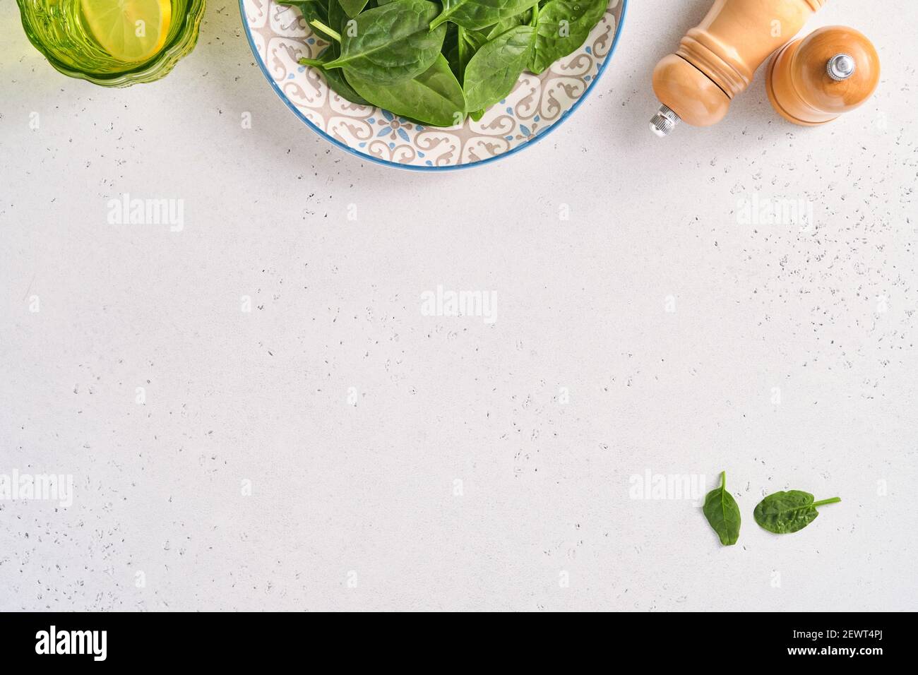 Composition with spinach, measuring tape, blank paper notebook and pink ...