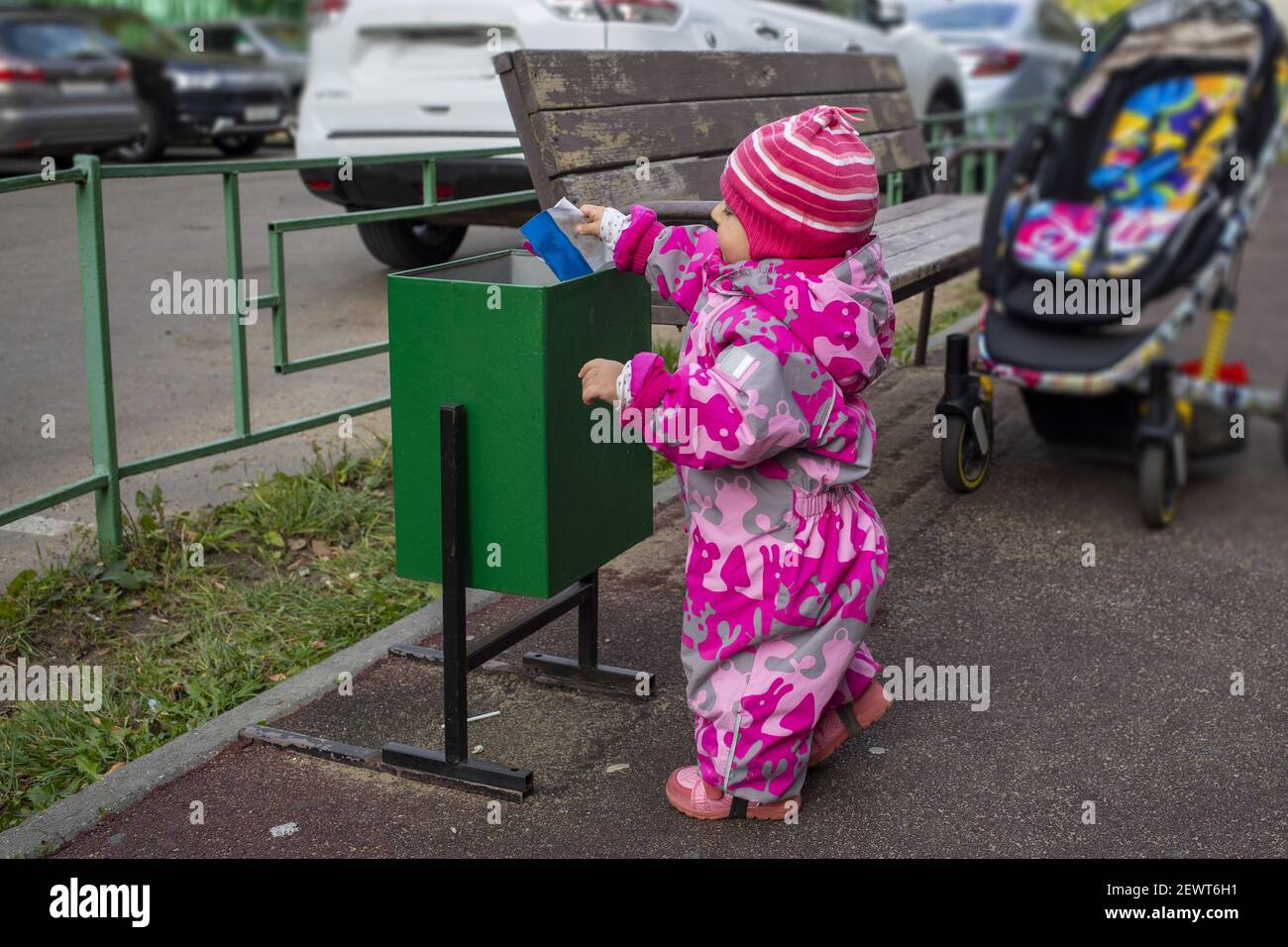 adorable kid throws trash in a street bin Stock Photo - Alamy