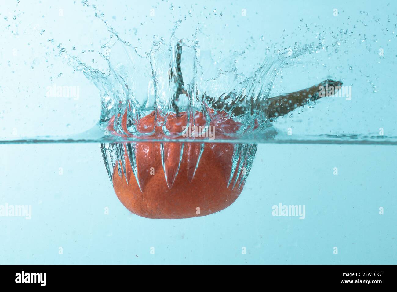 A mandarin falling into water with splash Stock Photo - Alamy