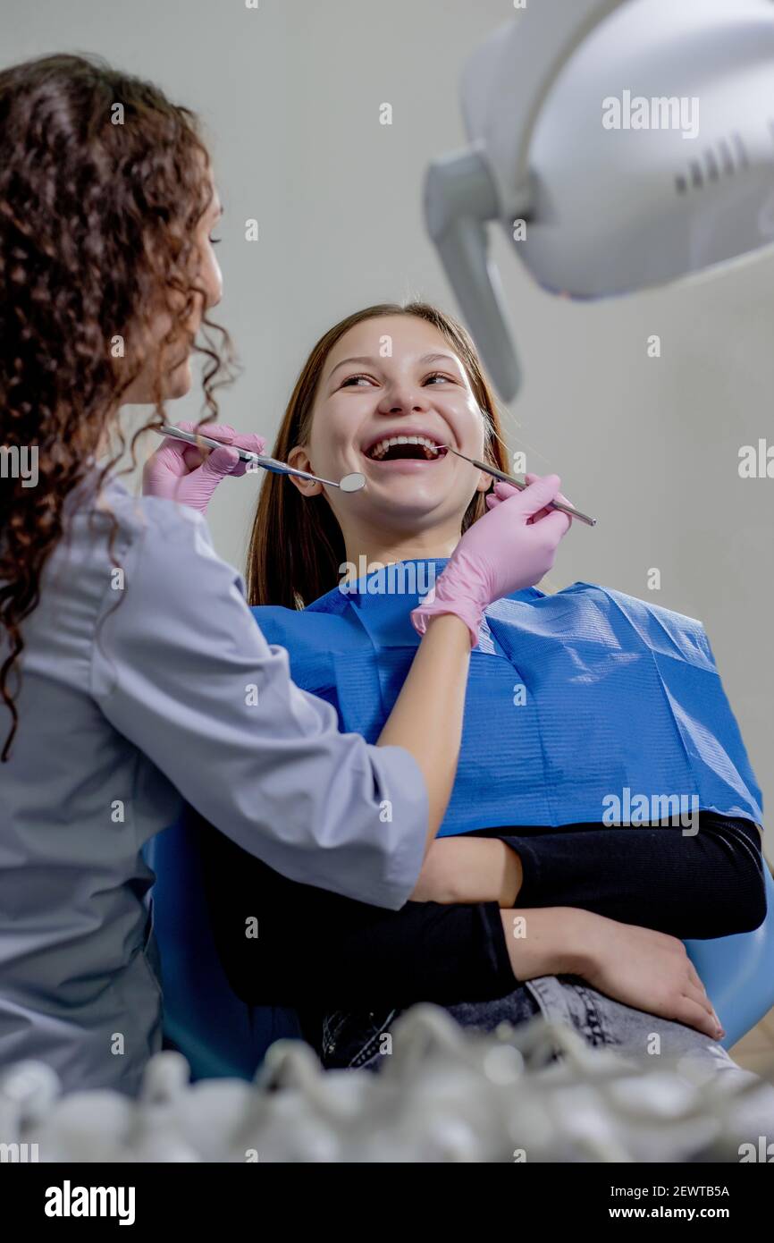 Professional doctor dentist examine and treat spoiled teeth with the ...