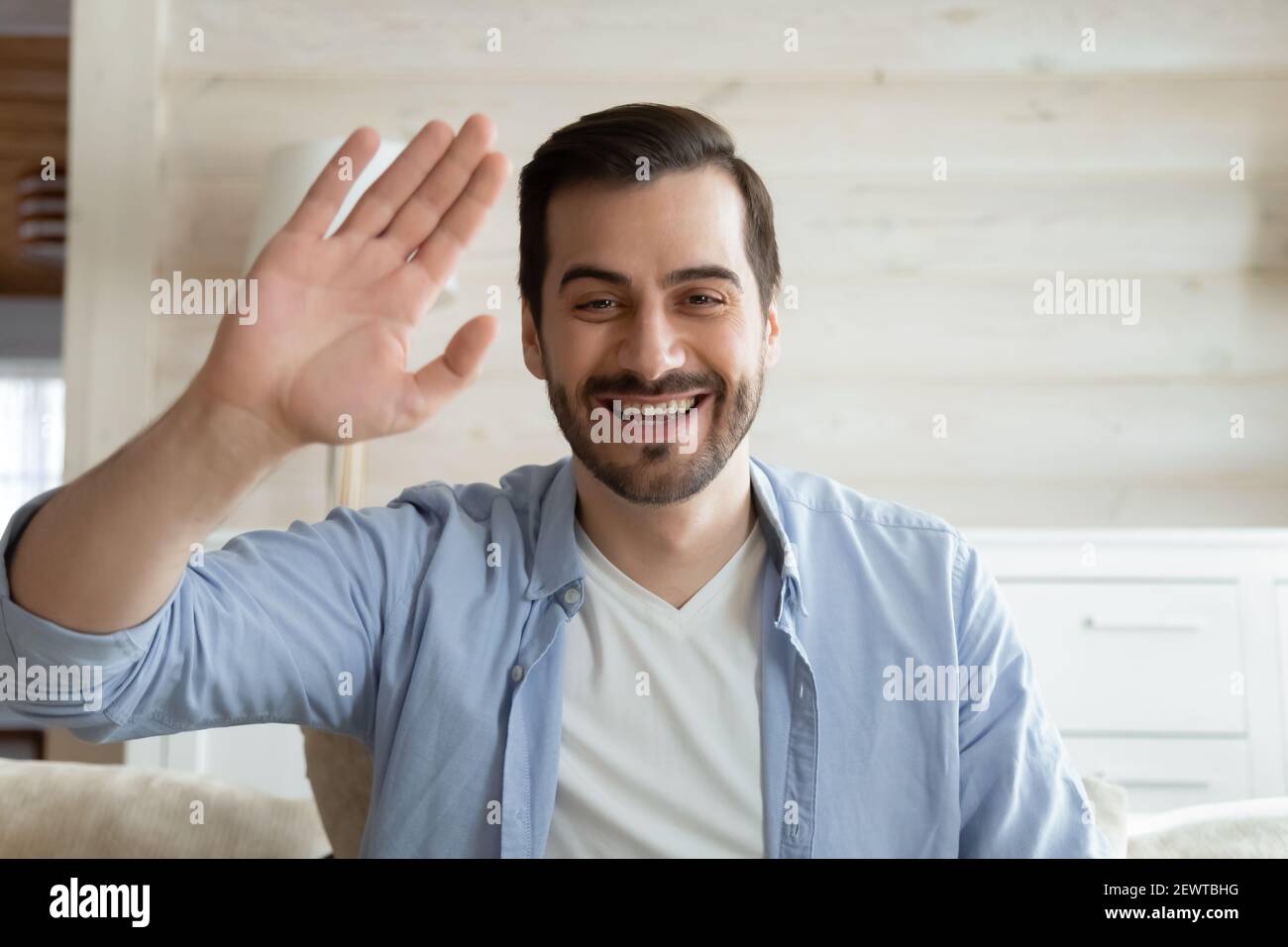 Smiling young man wave to camera talking on video call Stock Photo - Alamy