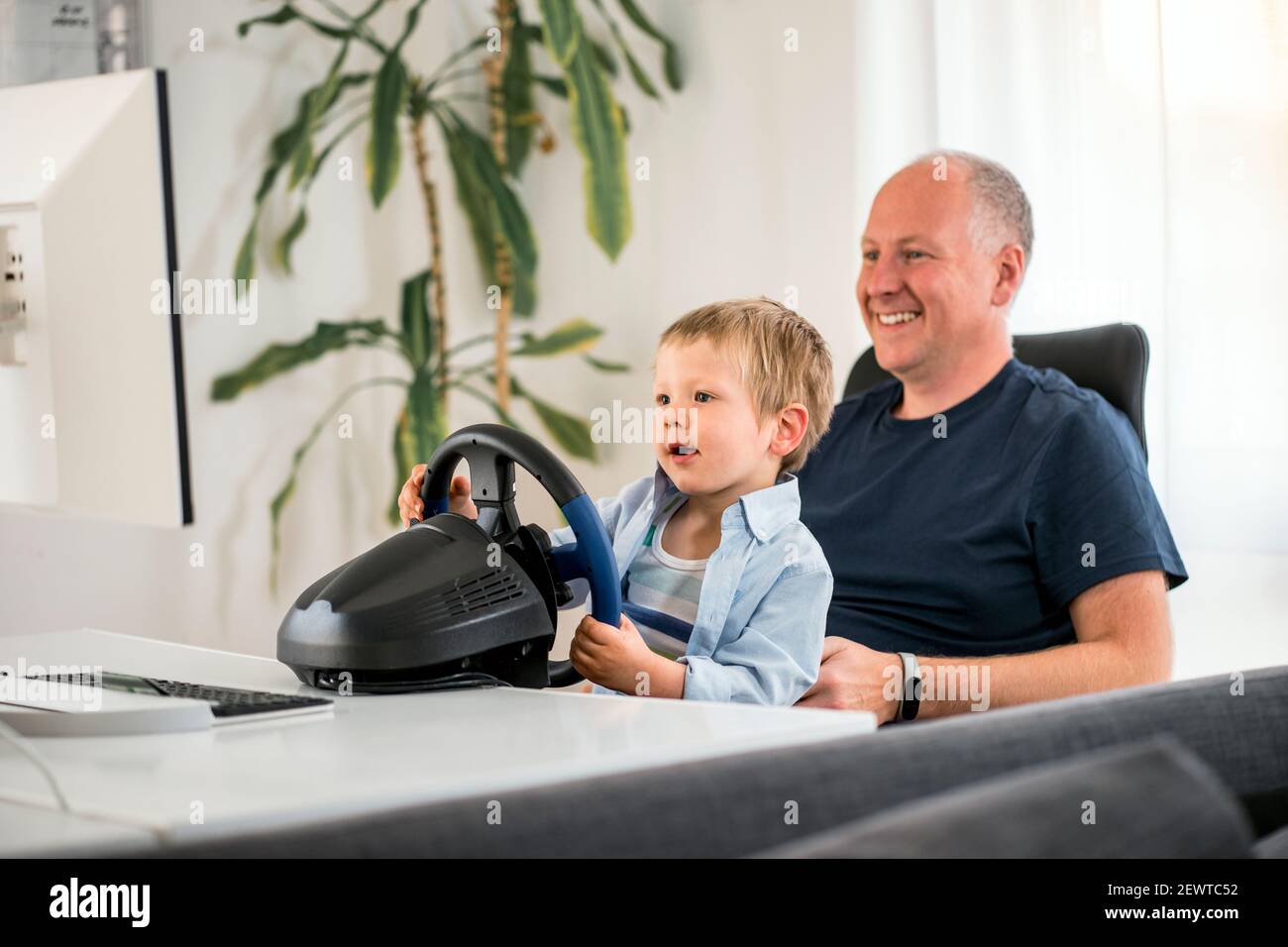 Father and son having fun playing racing car games on computer using ...