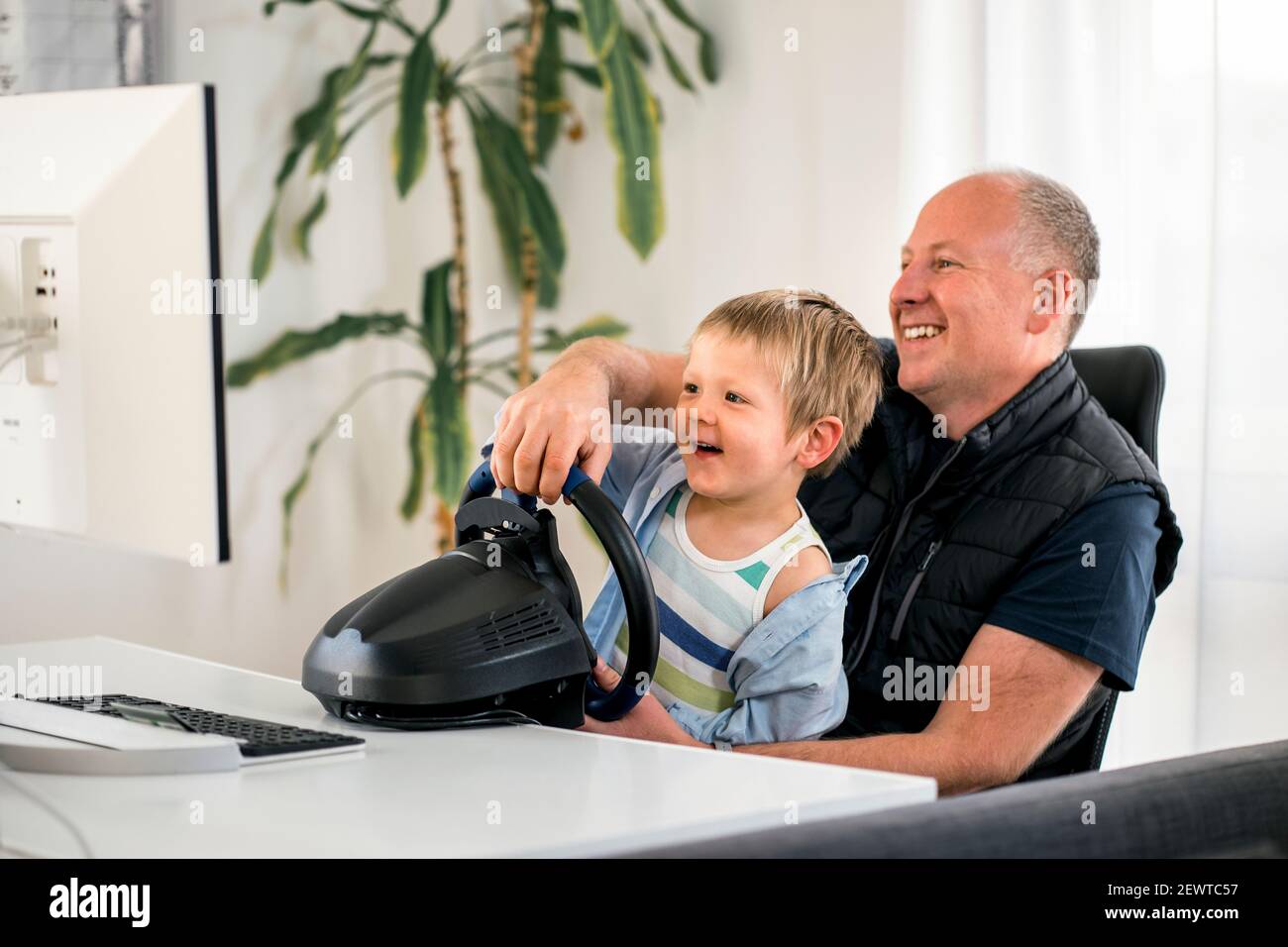 Father and son having fun playing racing car games on computer using ...
