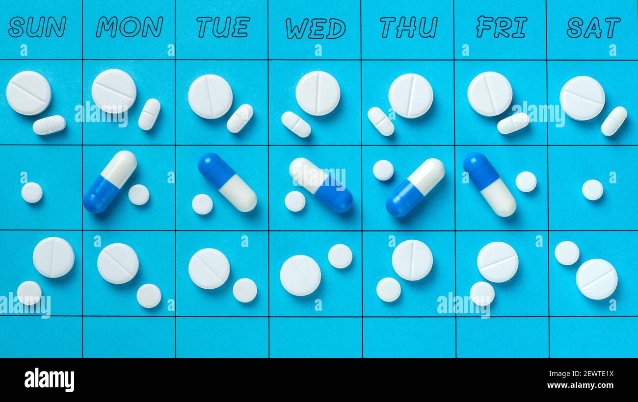Daily and weekly medication schedule. Various pills and capsules on a ...