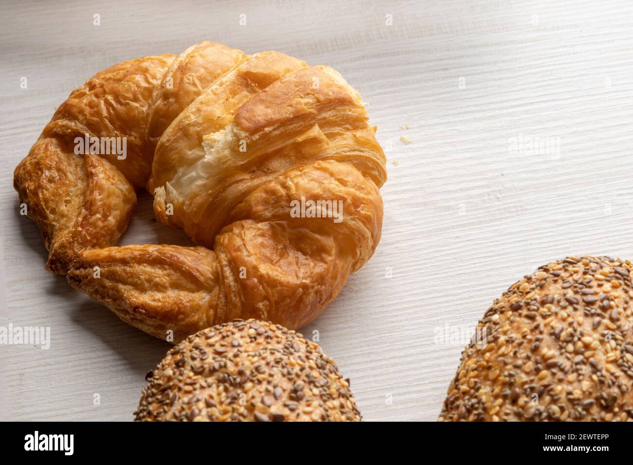 closeup to several breads including a croissant, background the wood ...