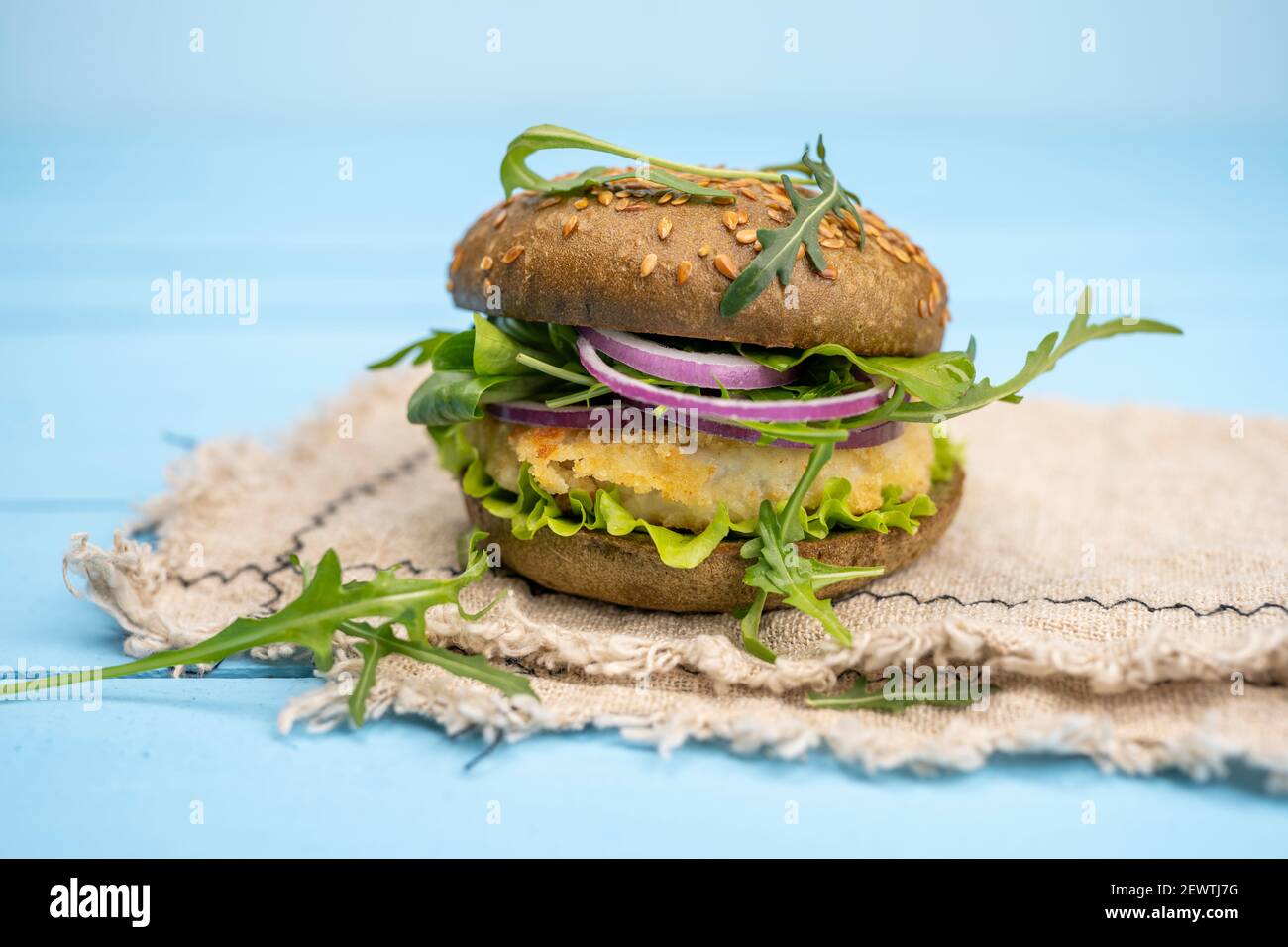Healthy fish burger with arugula on blue background Stock Photo - Alamy