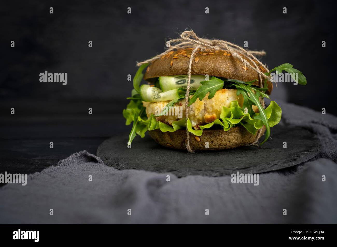 Vegetarian American Cuisine. Burger with fish, arugula, cucumbers ...