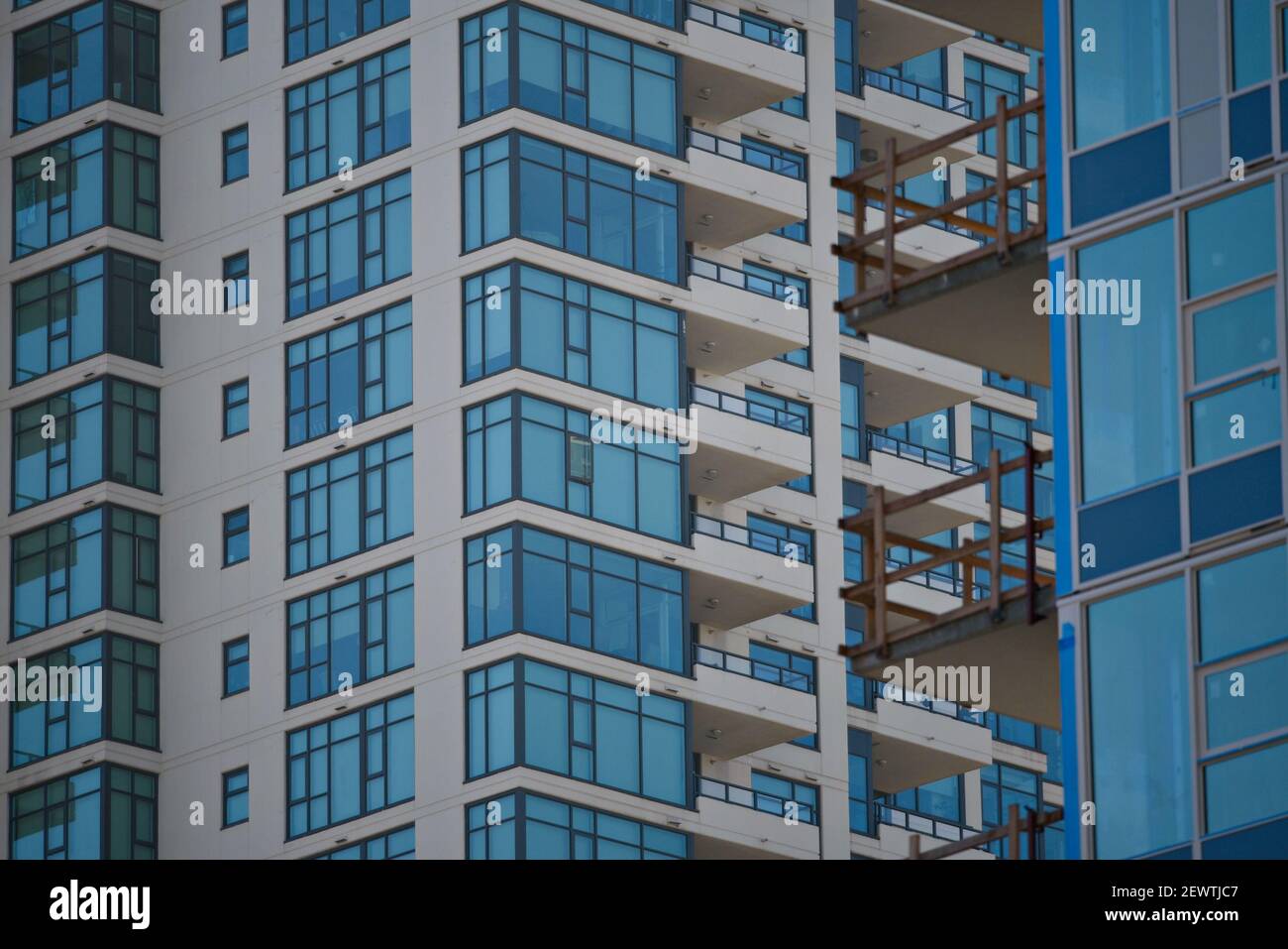 Condominiums high-rise building facade with symmetrical green glass ...