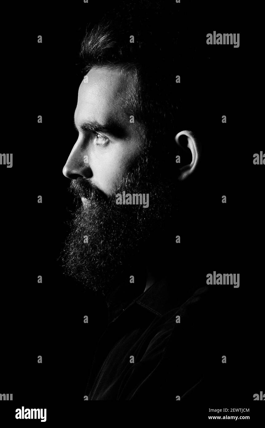 Portrait of a bearded man in a studio environment in front of a black ...