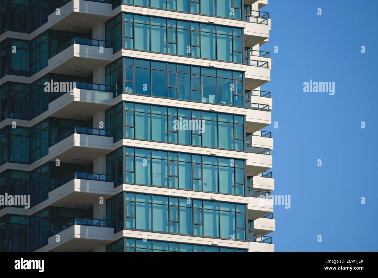 Condominiums high-rise building facade with symmetrical green glass ...
