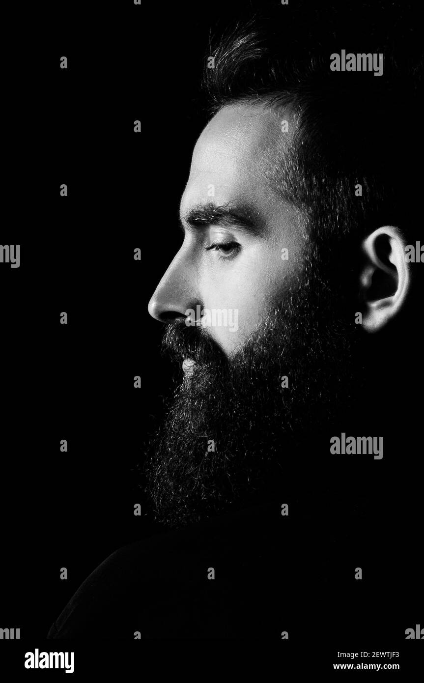 Portrait of a bearded man in a studio environment in front of a black ...