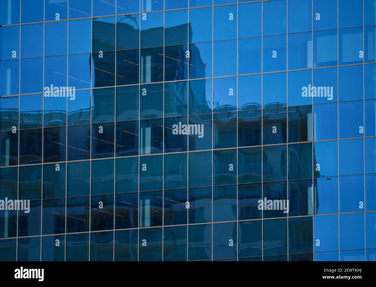 Corporate offices high-rise building blue glass facade with reflections ...