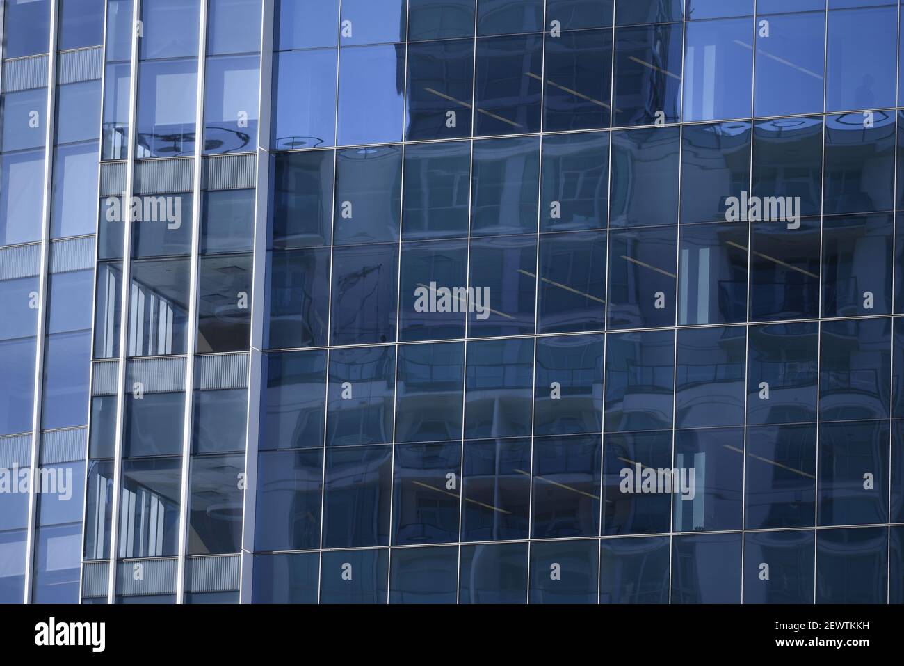 Corporate offices high-rise building blue glass facade with reflections ...