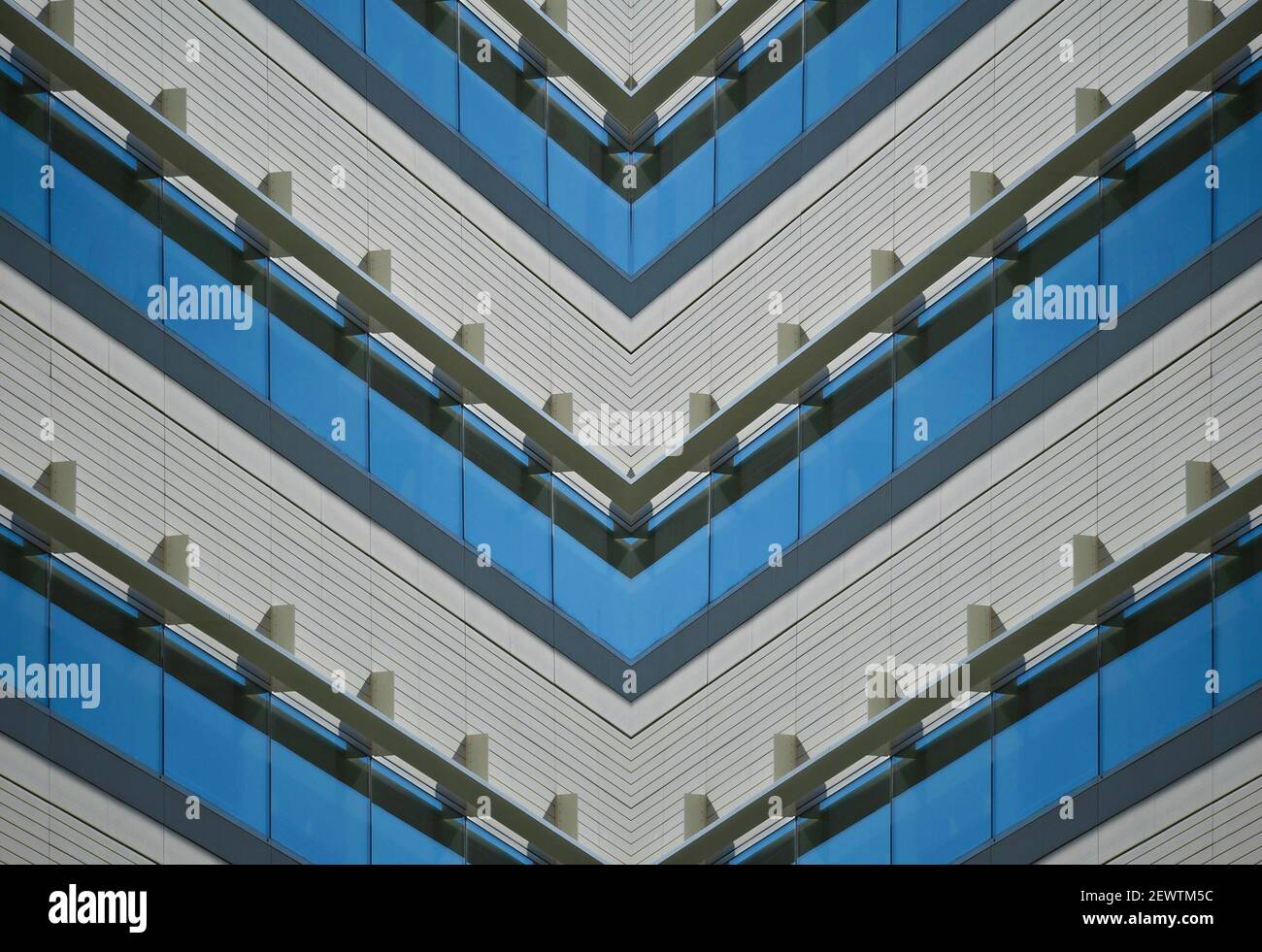 Corporate offices high-rise building facade with symmetrical blue glass ...
