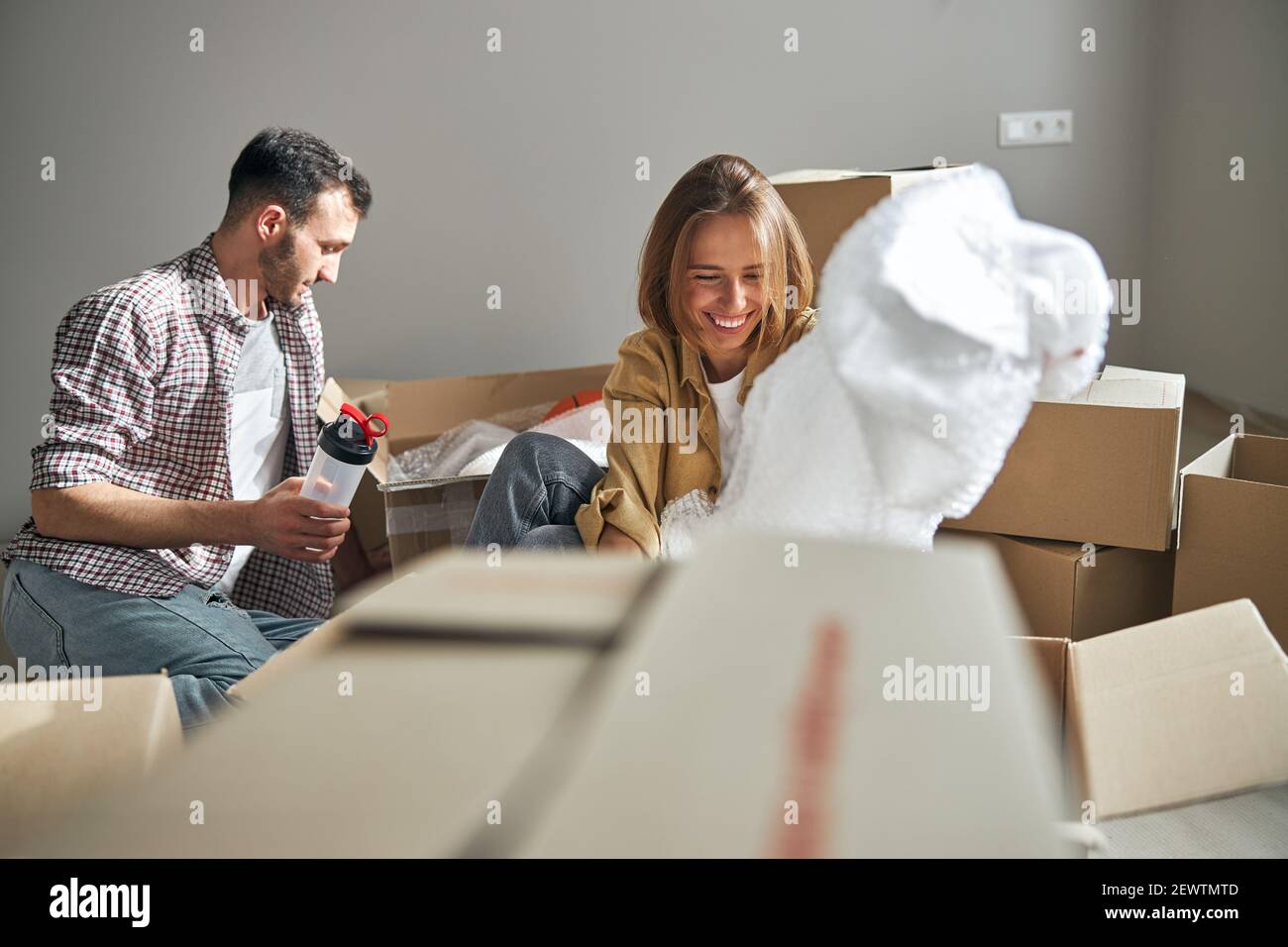 Young couple unpacking things in their new apartment Stock Photo - Alamy