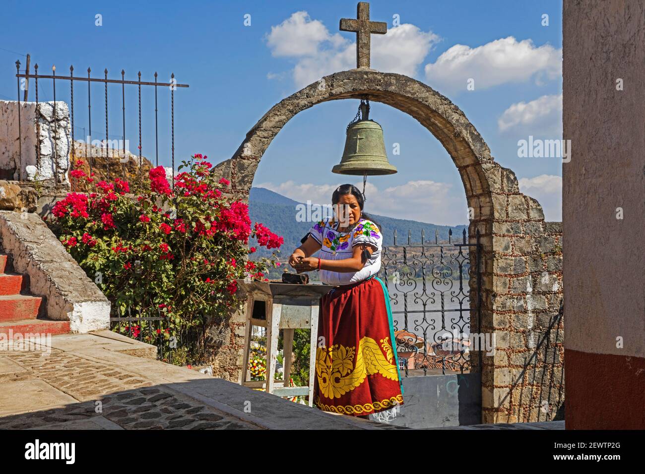 Mexican woman in traditional dress at entrance gate to the cemetery on ...
