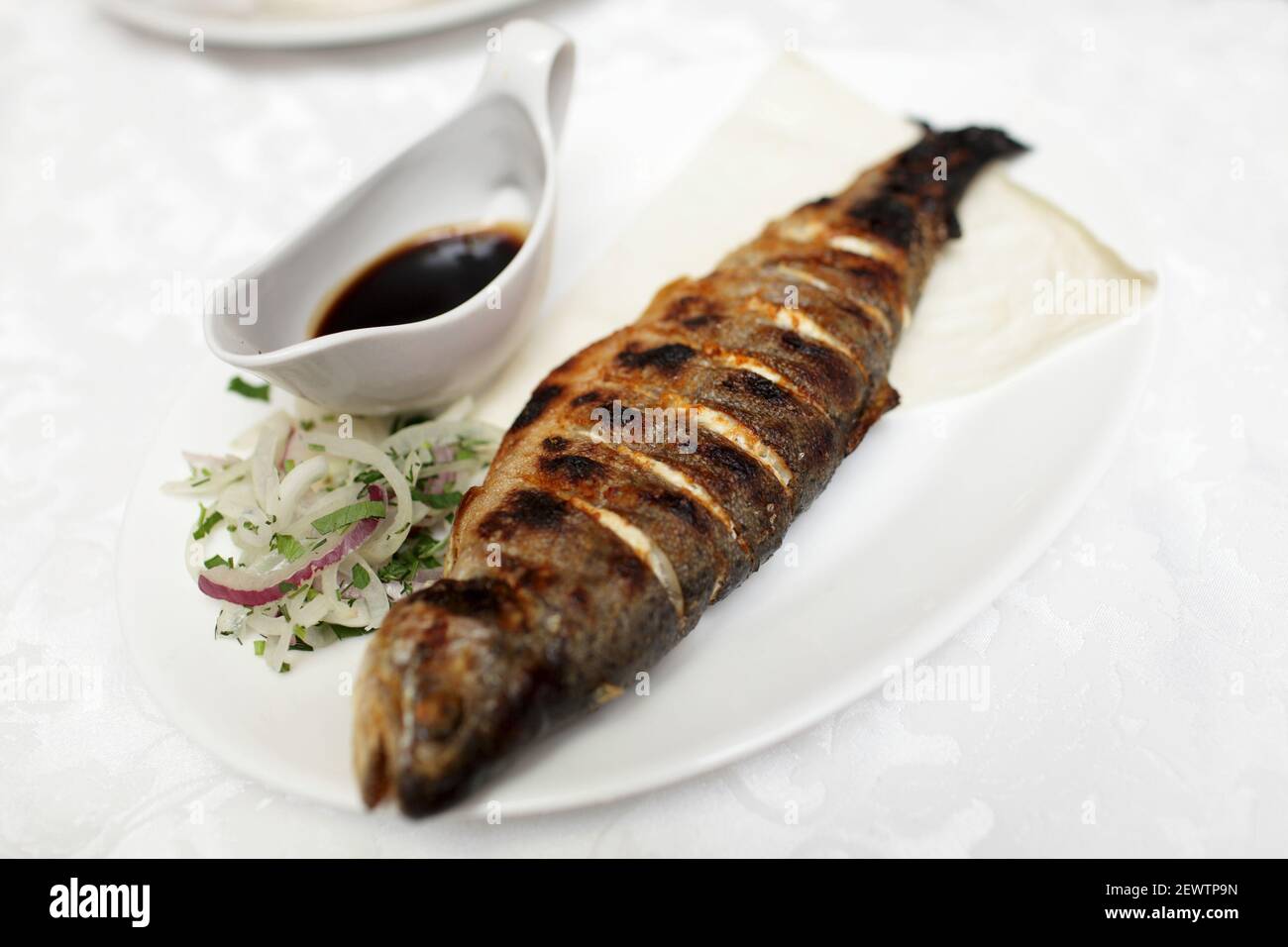 Plate with fried trout on a table in the restaurant Stock Photo - Alamy
