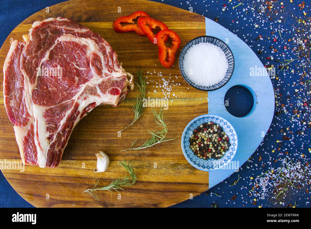 A top view of a slice of raw beef steak on a kitchen table with spices ...