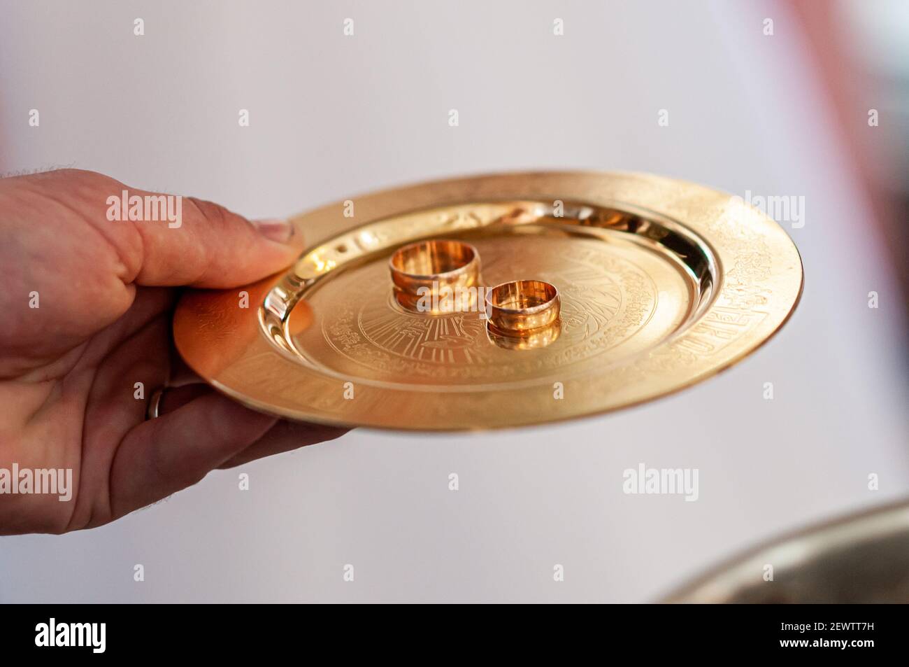 Wedding rings on a golden plate Stock Photo - Alamy
