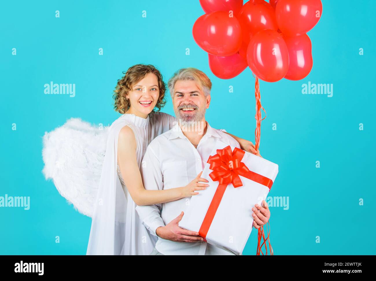 Couple in valentine day with heart balloons and gift. Family angels ...