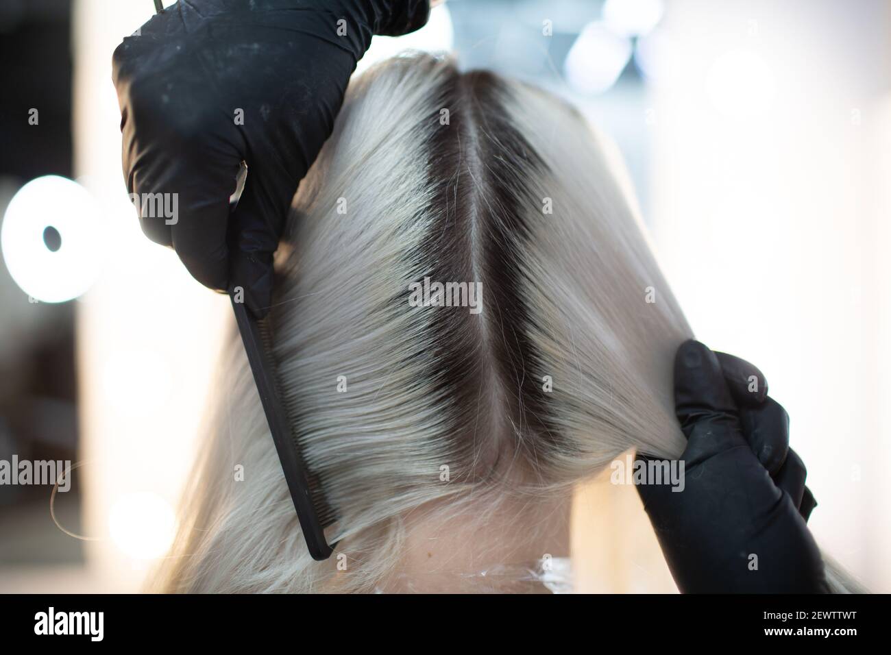 Young woman hairdresser dying hair at beauty salon. Professional hair ...