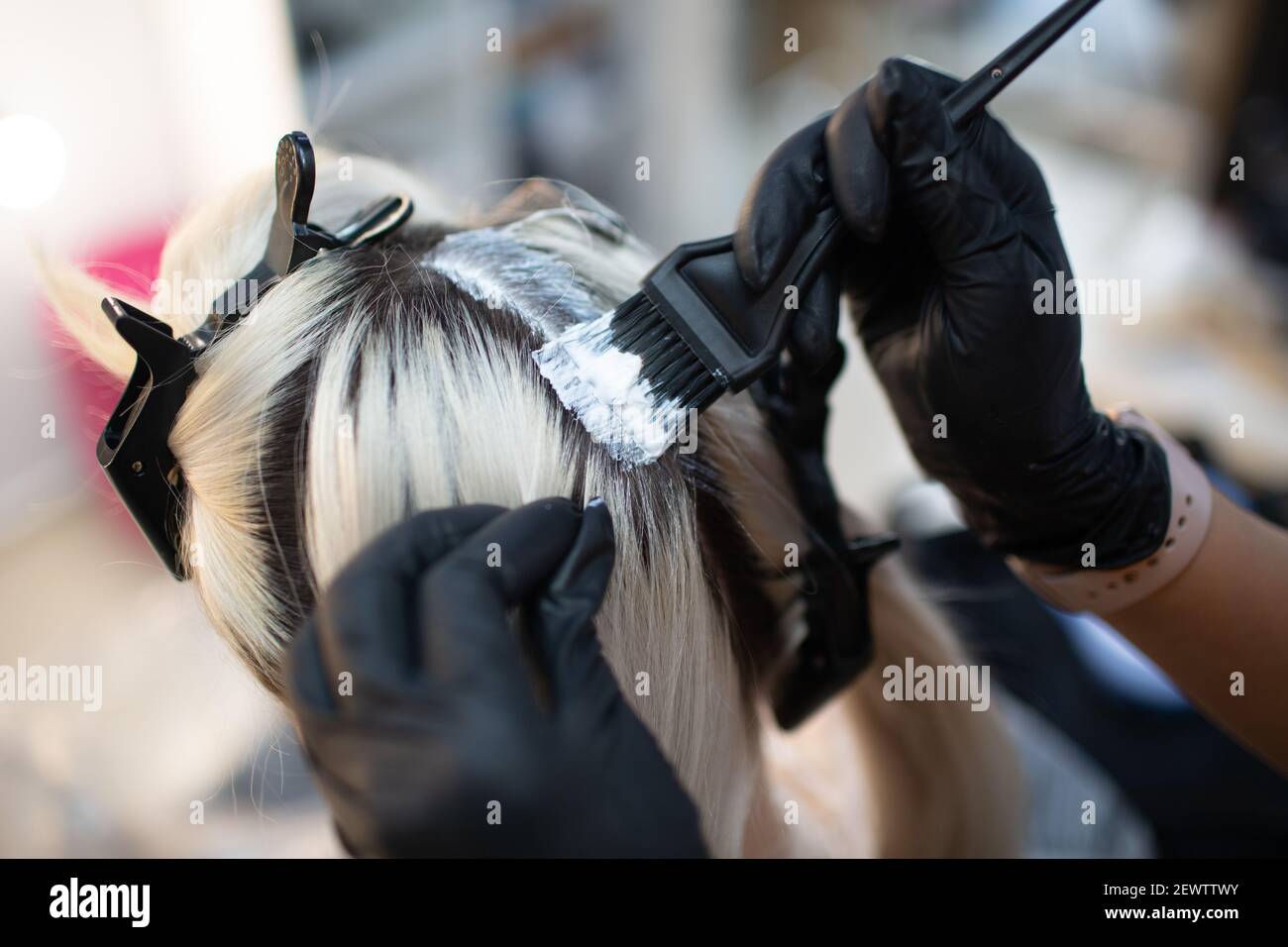 Young woman hairdresser dying hair at beauty salon. Professional hair ...