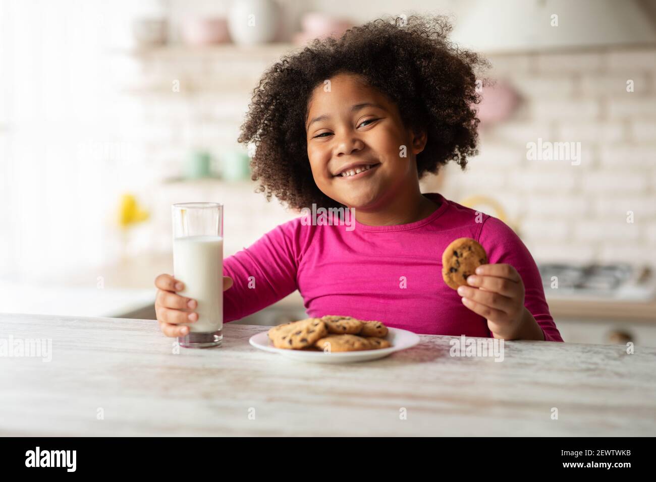 Tasty Snack. Cheerful Black Girl Eating Cookies And Drinking Milk In ...