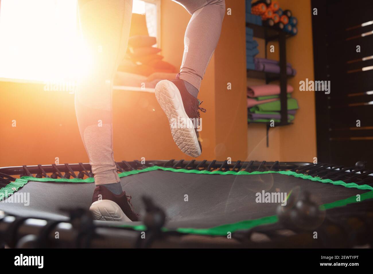 Closeup step fitness woman jumping on mobile mini trampoline Stock ...